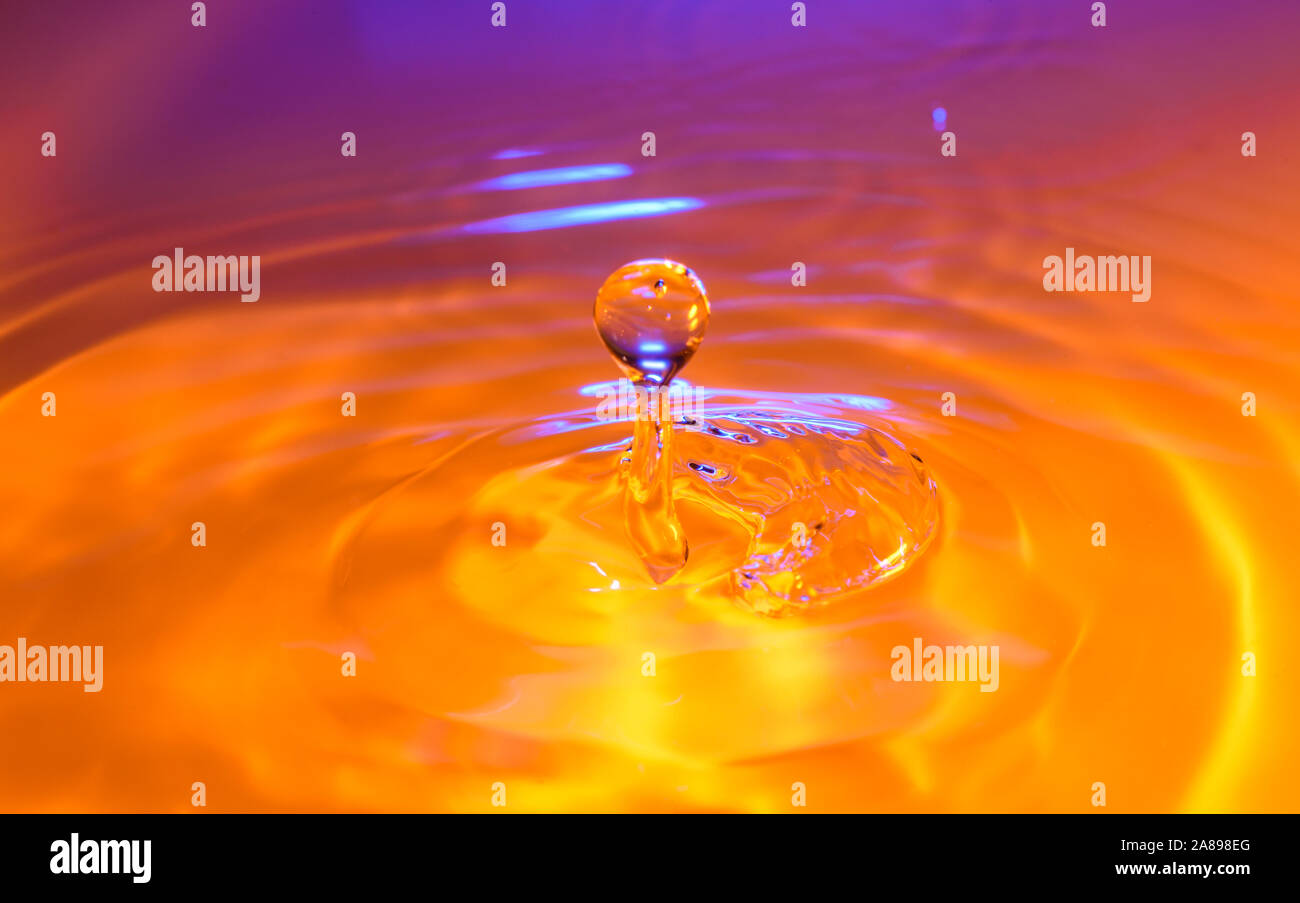 Orange and purple splashing water Stock Photo - Alamy