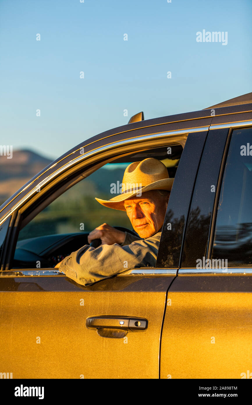 Farmer wearing cowboy hat driving SUV Stock Photo - Alamy