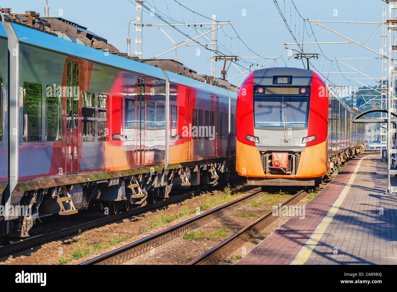 Passenger train stands along the platform by the Black sea coast. Sochi ...
