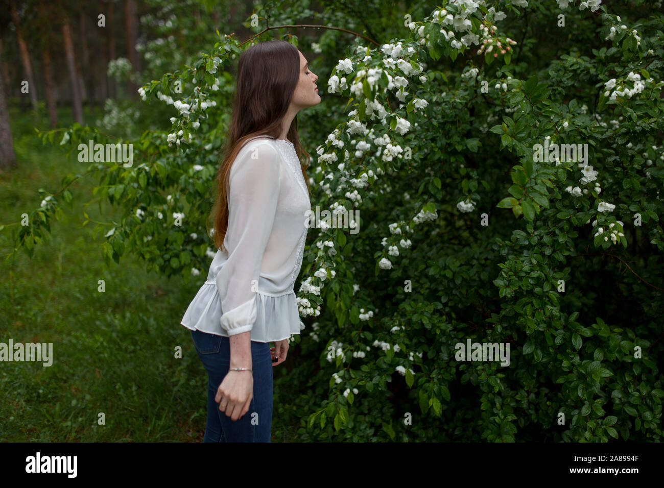 Young woman smelling flowers Stock Photo - Alamy