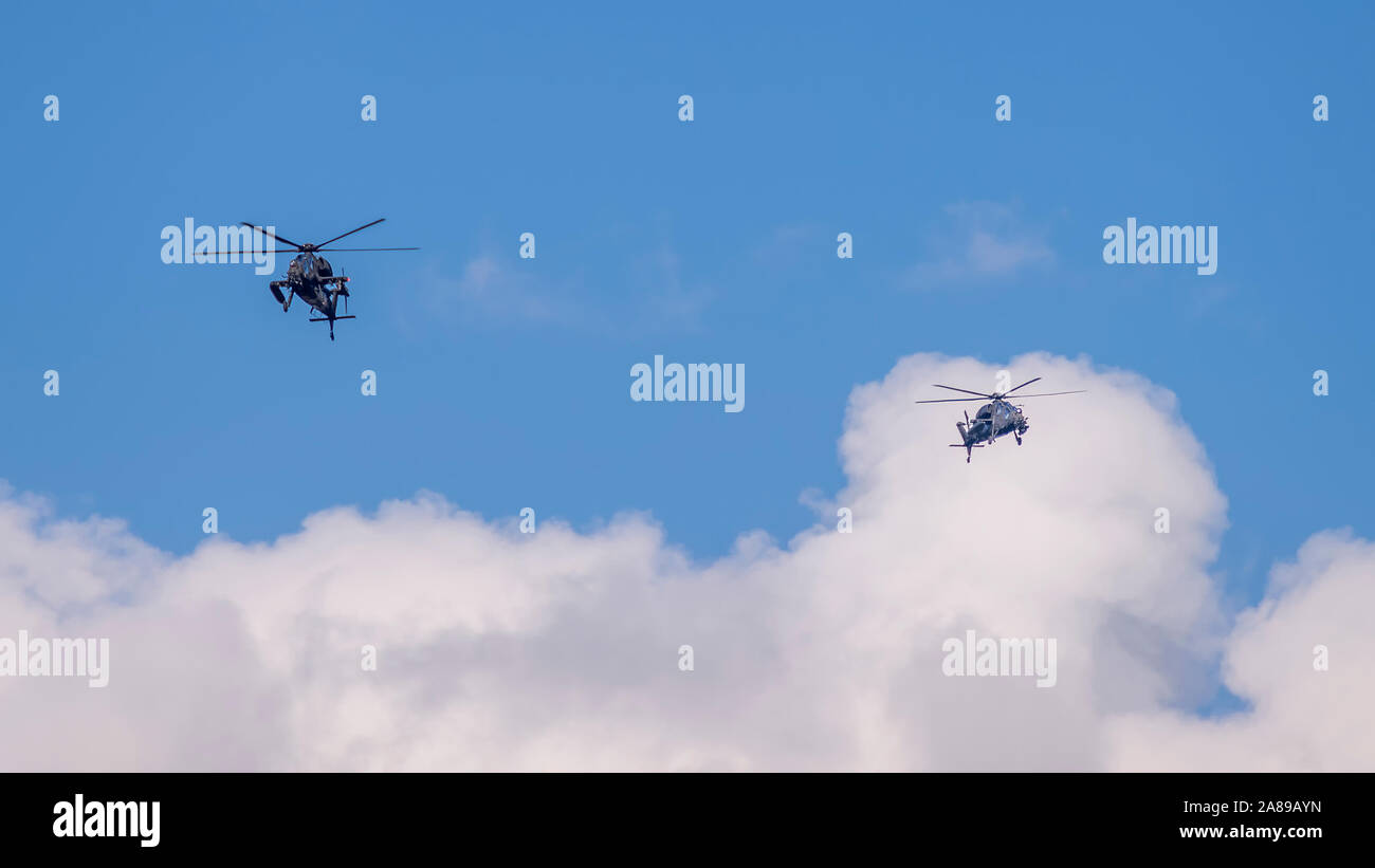 Two military helicopters flying against a beautiful sky with clouds ...
