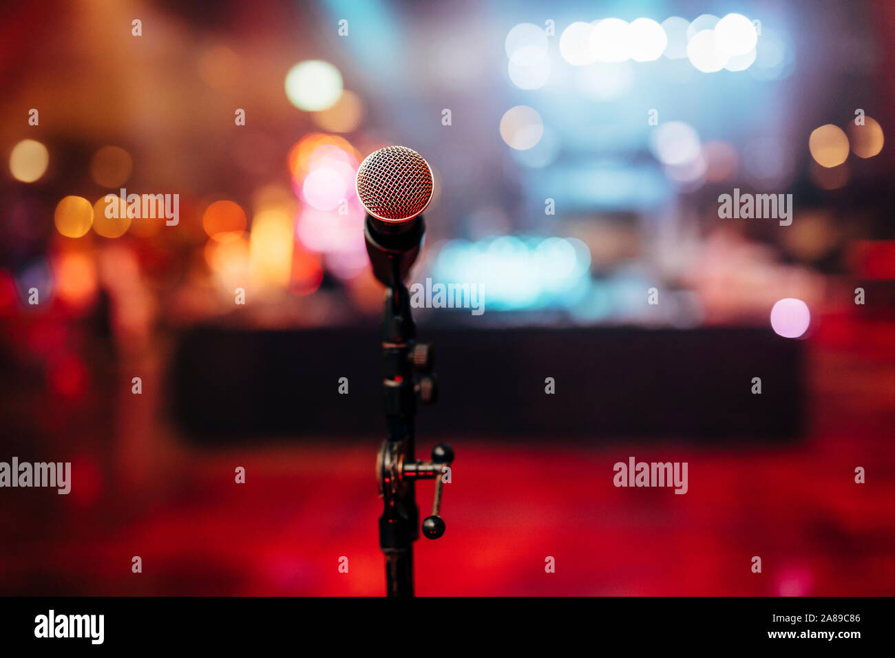 MIC ON A STAGE READY FOR THE SINGER OR SPEAKER WITH BLURRED BCKGROUND ...