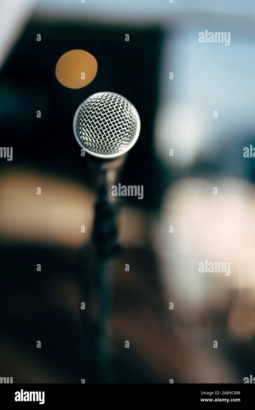 MIC ON A STAGE READY FOR THE SINGER OR SPEAKER WITH BLURRED BCKGROUND ...