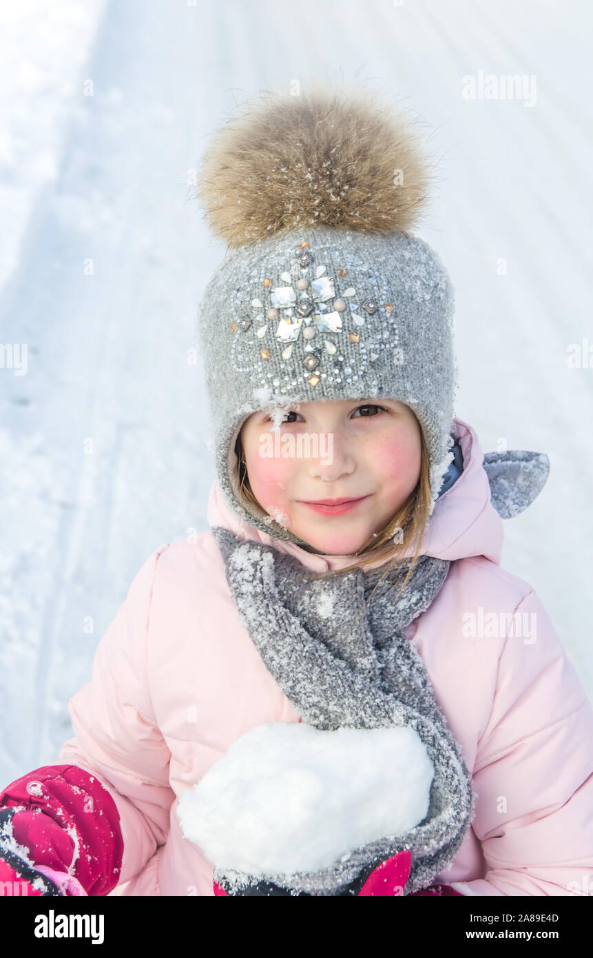 Winter little girl holds snow in her hands fun Stock Photo - Alamy