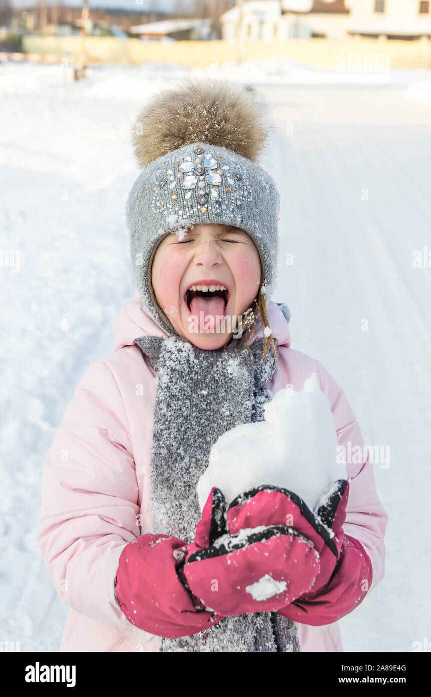 Winter little girl holds snow in her hands fun Stock Photo - Alamy
