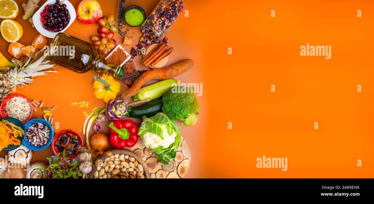 Mixed colorful foods as nuts, fruits, vegetables, beans, herbs, powders ...