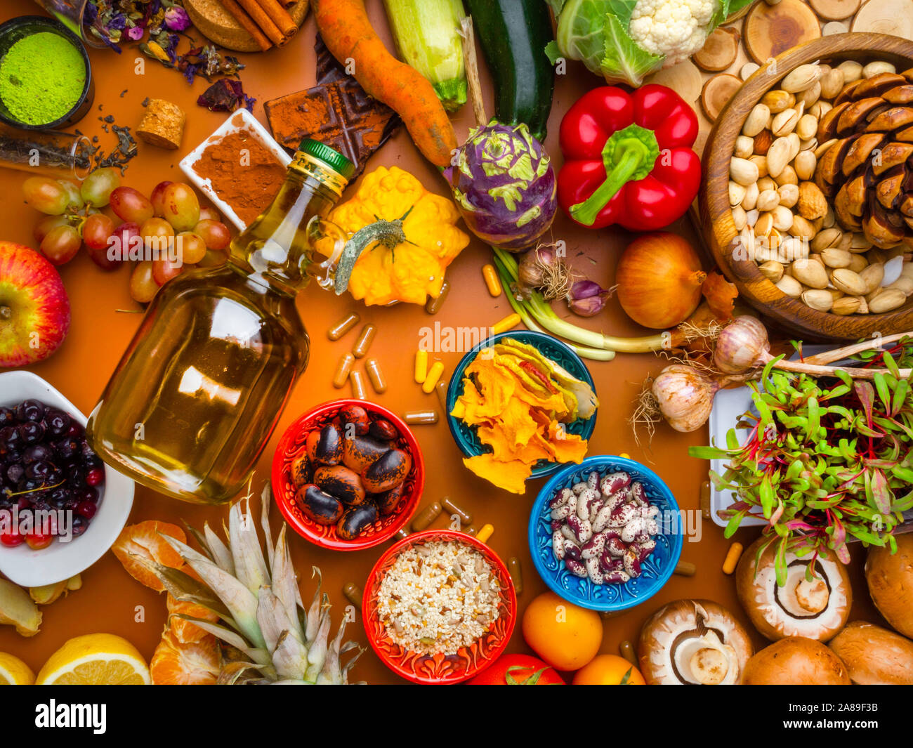Mixed colorful foods as nuts, fruits, vegetables, beans, herbs, powders ...