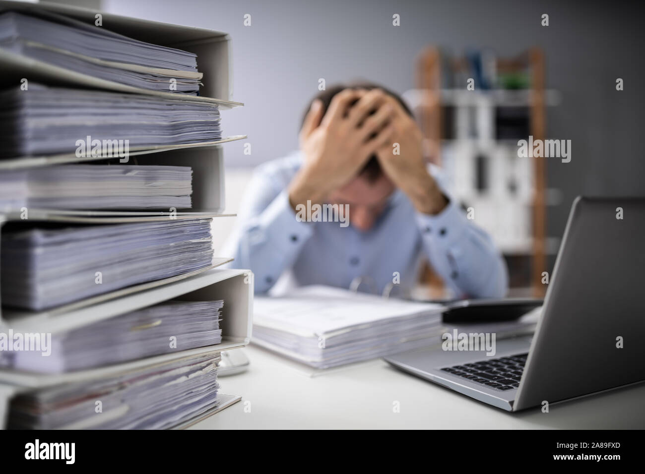 Photo Of Overworked Businessman Doing Taxes At Office Stock Photo - Alamy
