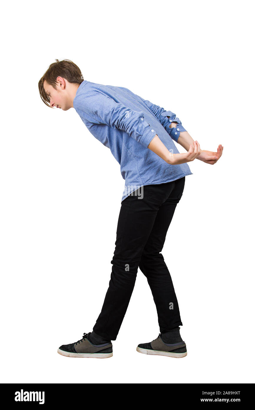 Bent down teenage guy keeps hands back as carrying an heavy invisible ...