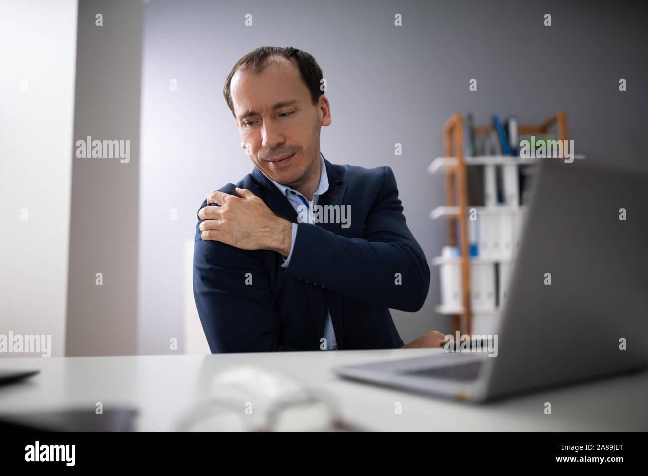 Young Businessman Using Computer Suffering From Shoulder Ache Stock ...