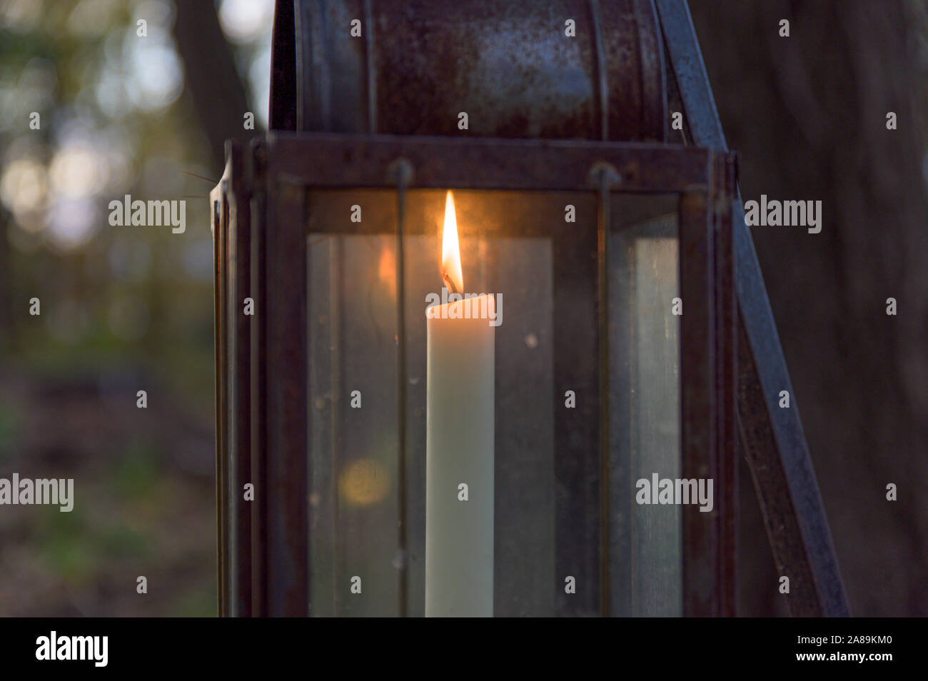 An old-fashioned candle lit lantern during early evening hours Stock ...