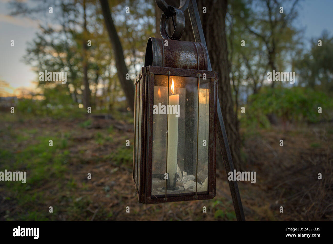 An old-fashioned candle lit lantern during early evening hours Stock ...