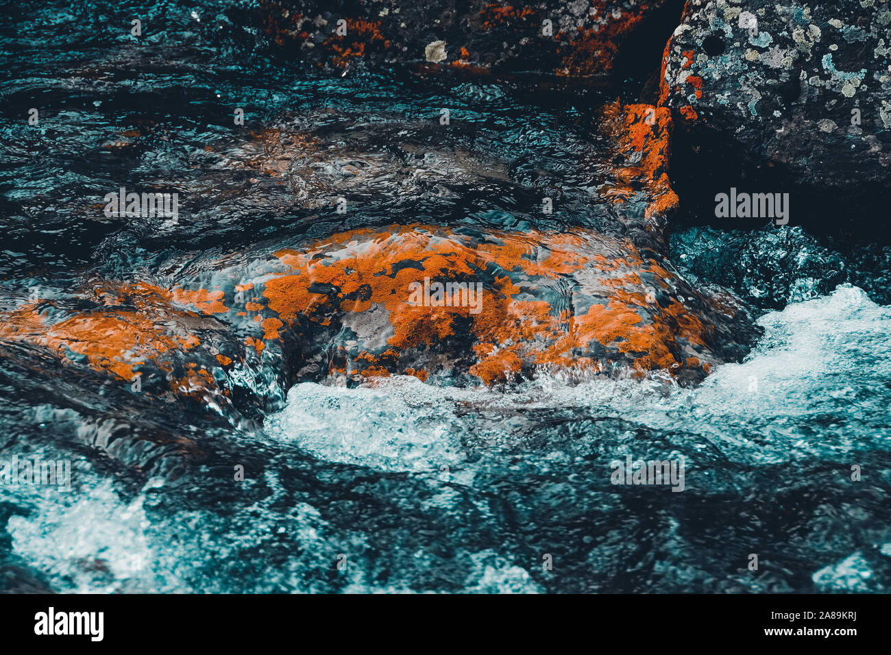 Strong mountain river. Rapid flow of stream among rocks. Blue stream of ...