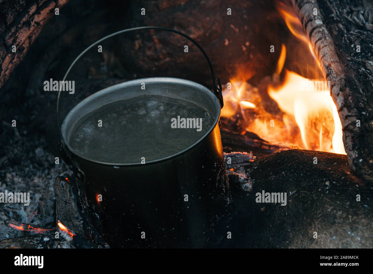 Tourist pot over the fire. Cooking in aluminum cookware. Survival in ...