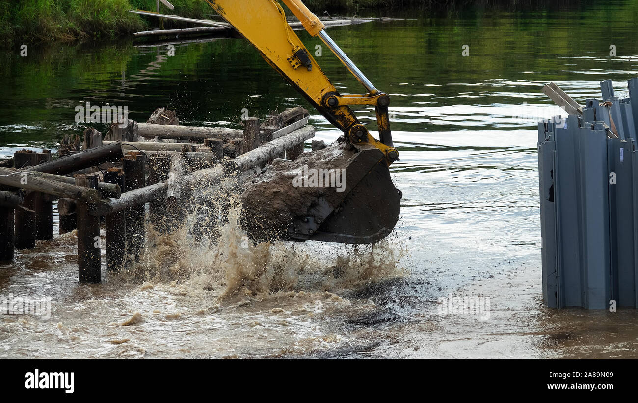 Excavator working in the small forest river, excavator bucket ...
