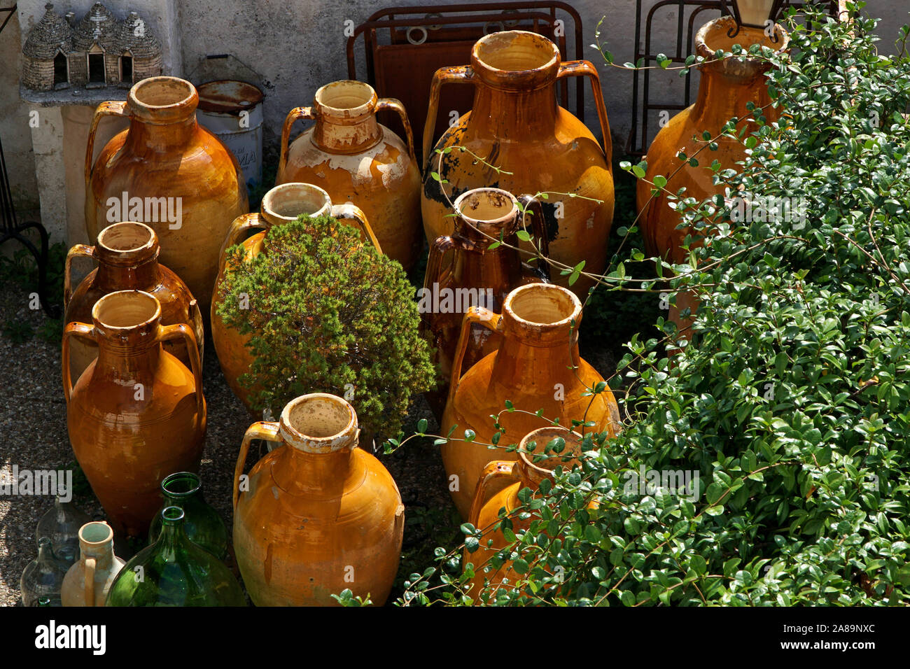 Olive oil jugs and vases in a Mediterranean garden Stock Photo - Alamy