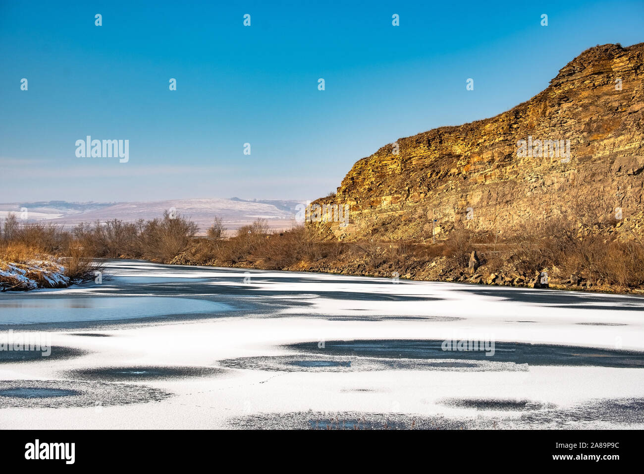 landscape, frozen river Bank, trees and grass in the snow Stock Photo ...