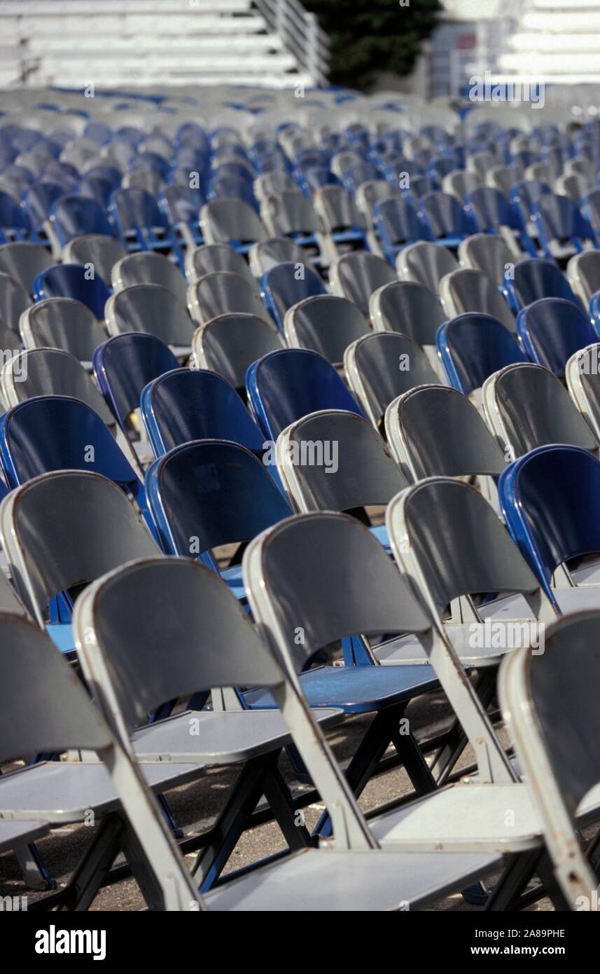 Lineup of a large group of empty folding metal chairs Stock Photo - Alamy