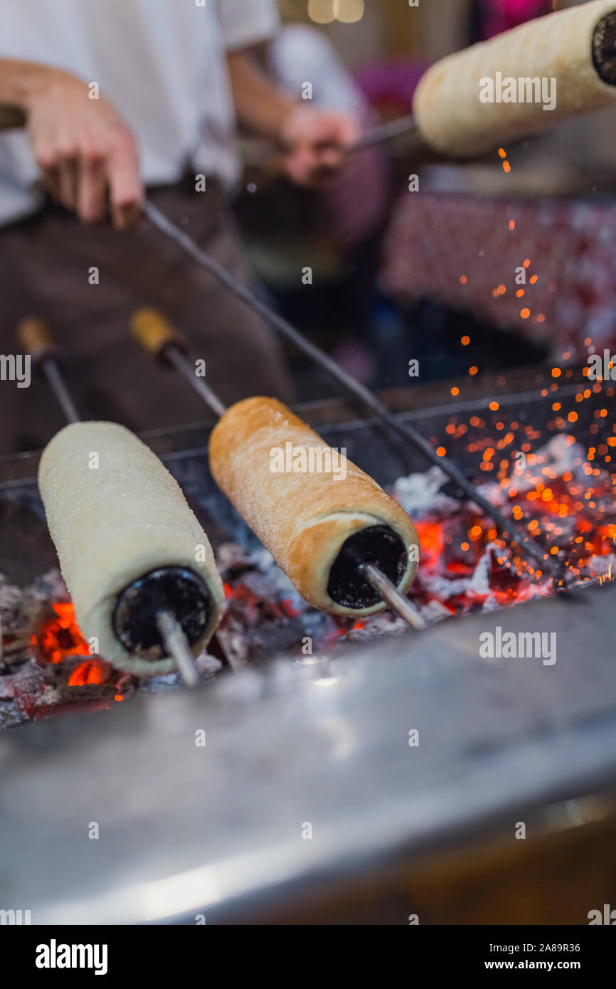 Chimney cake preparation. Chimney cake is being roasted over the fire ...