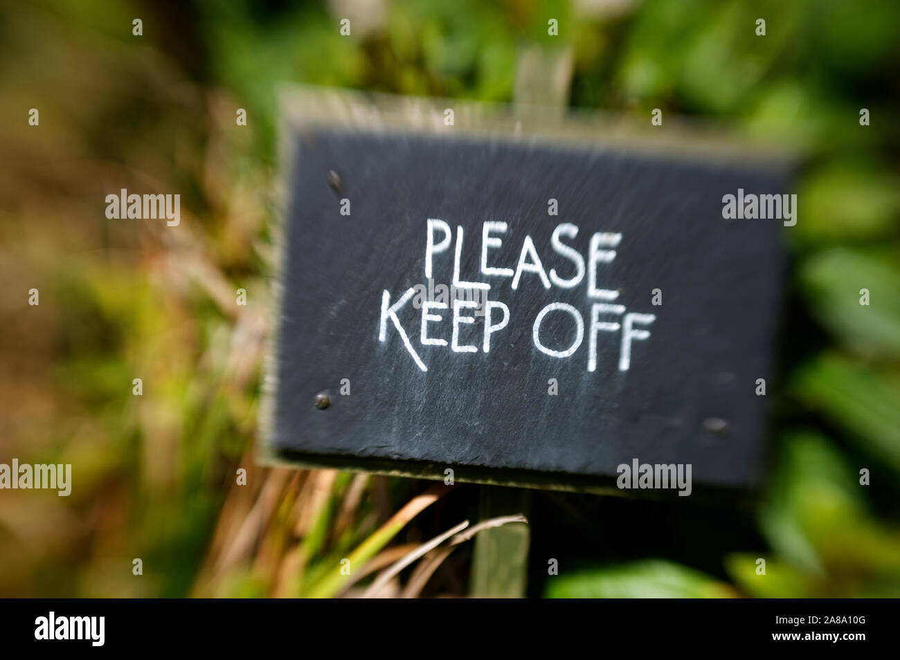 Tilt shift selective focus view of "Please Keep Off" sign with ...