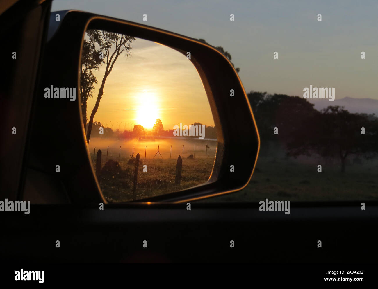 sunrise in the car mirror Stock Photo - Alamy