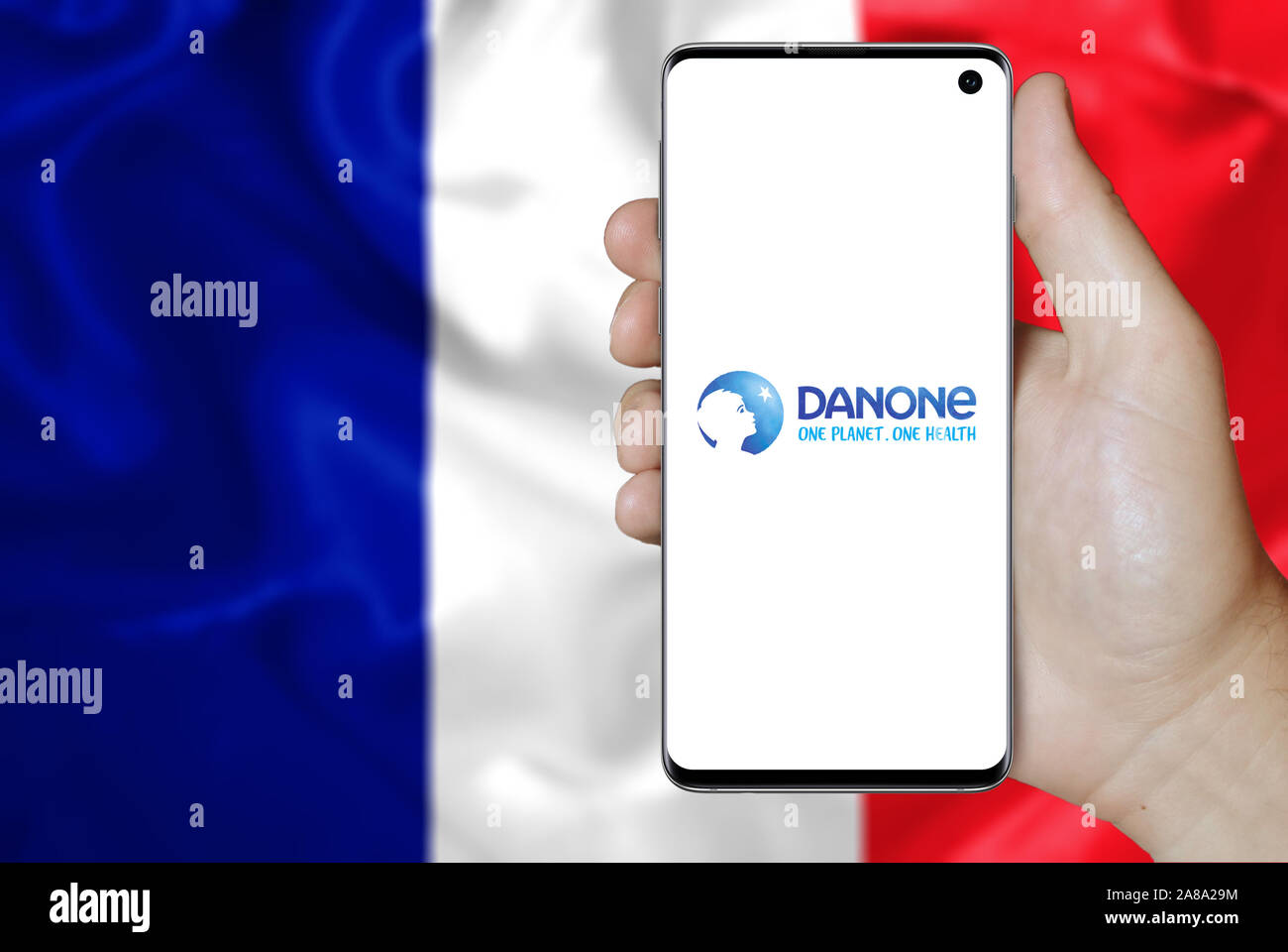 Logo of public company Danone displayed on a smartphone. Flag of France ...