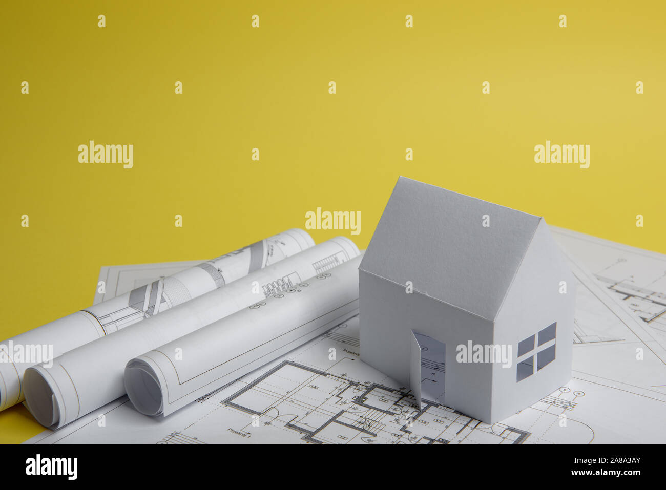 White family paper house, house projects plan and blueprints on yellow ...