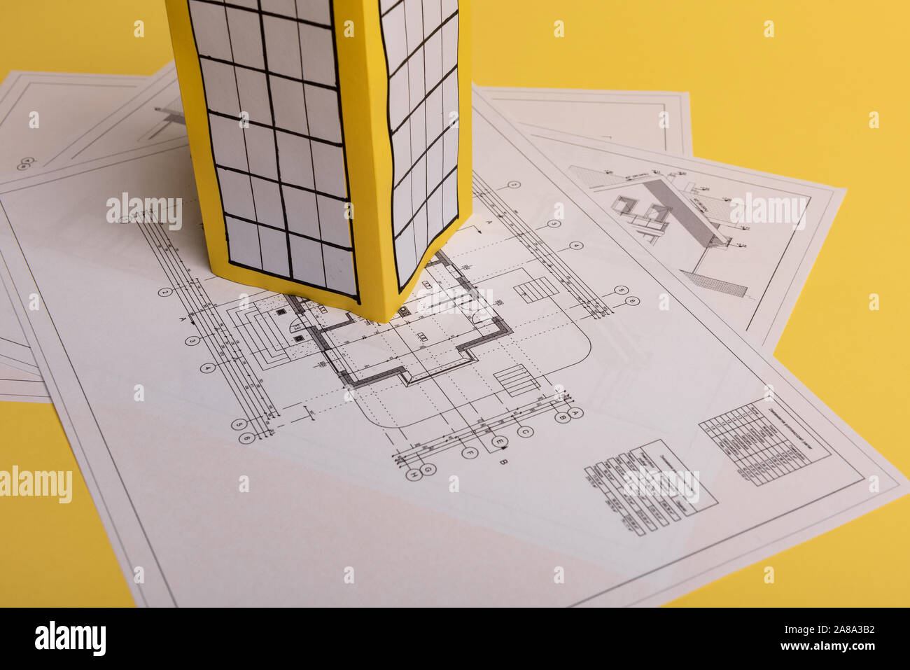 White family paper house, house projects plan and blueprints on yellow ...