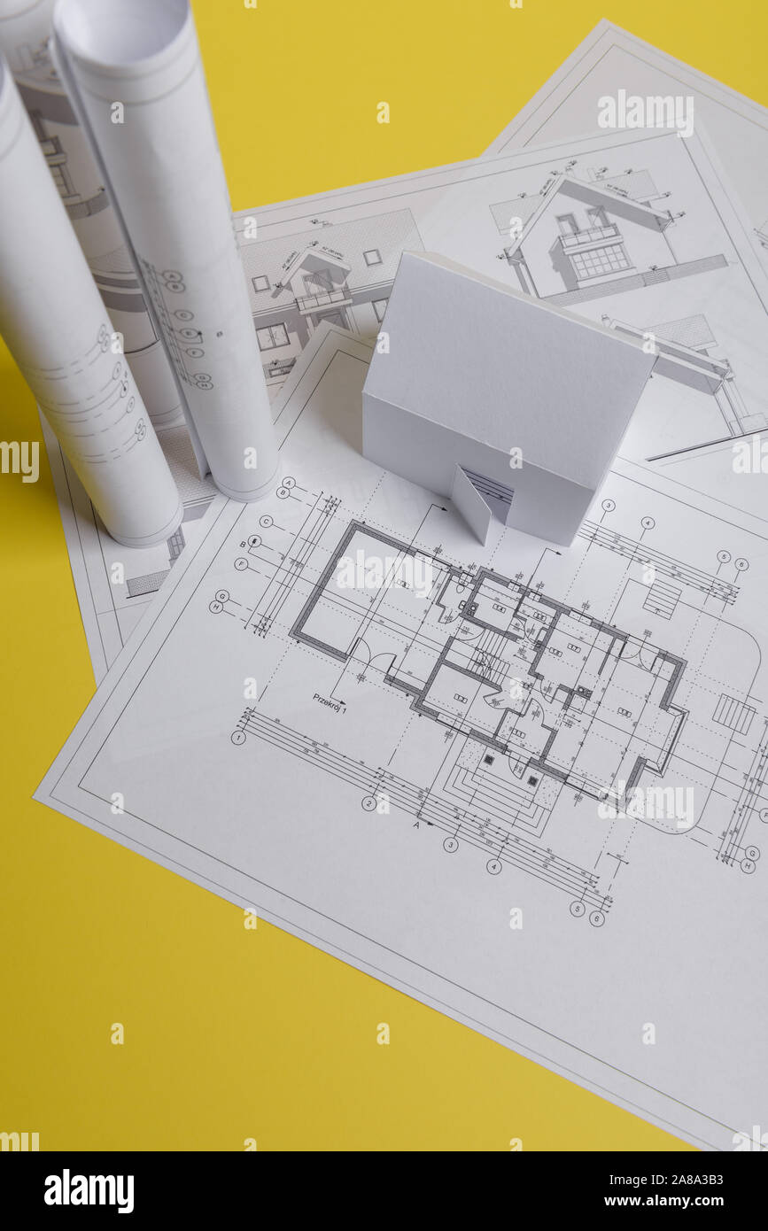 White family paper house, house projects plan and blueprints on yellow ...