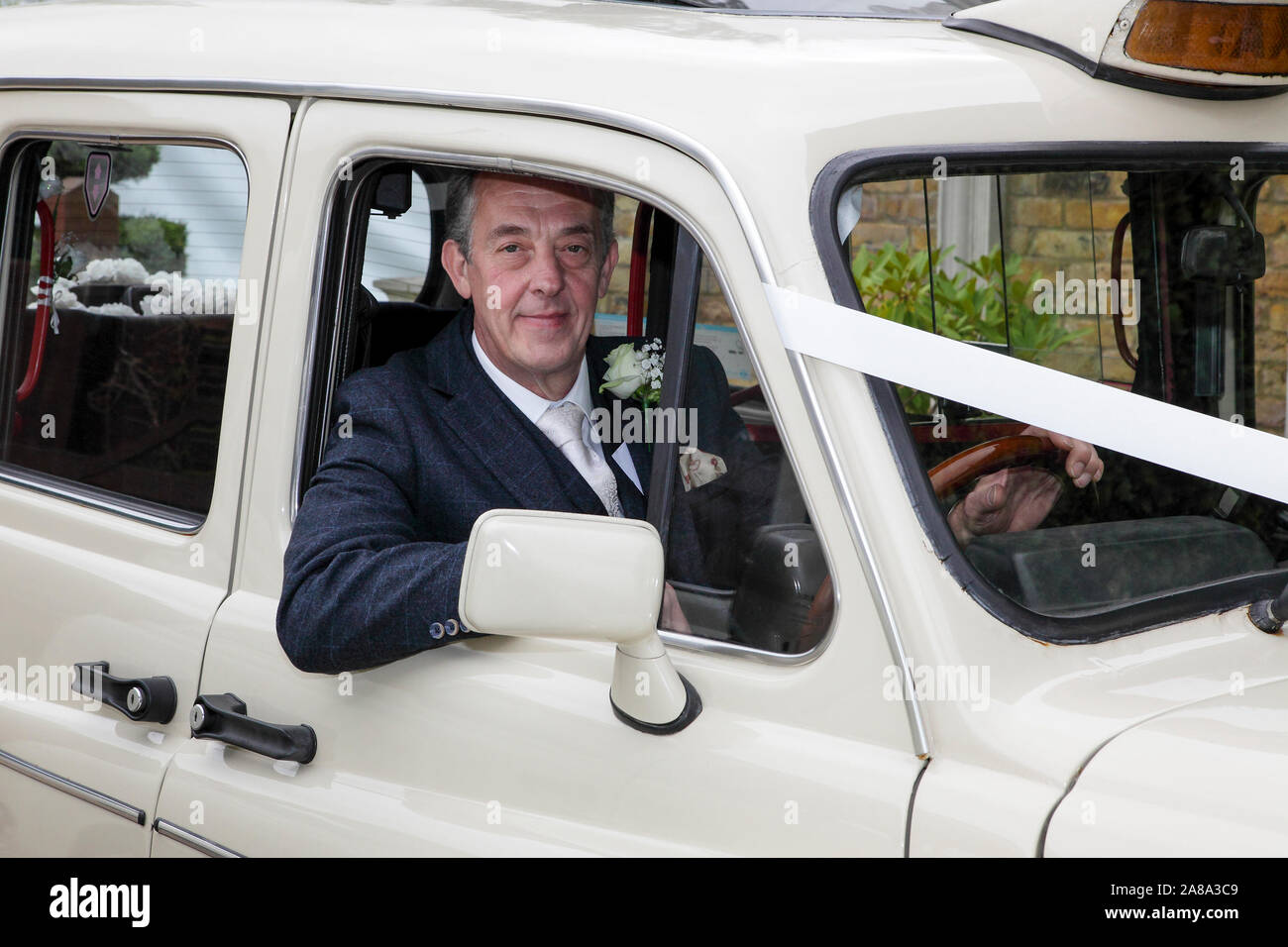 London Taxi driver sits in the front of his daughters wedding day taxi ...