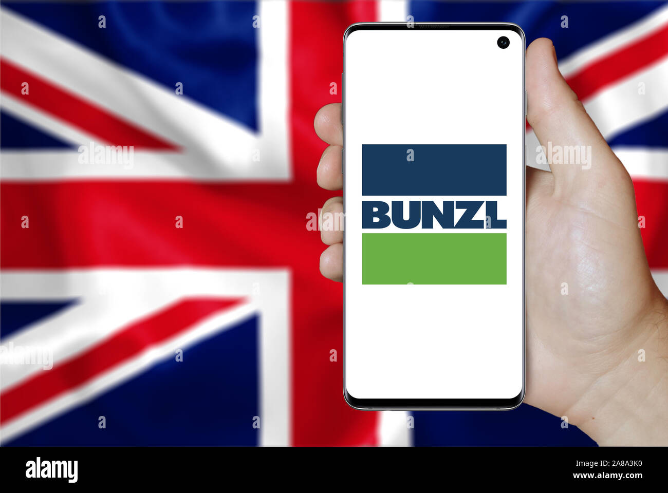 Logo of public company Bunzl displayed on a smartphone. Flag of UK ...