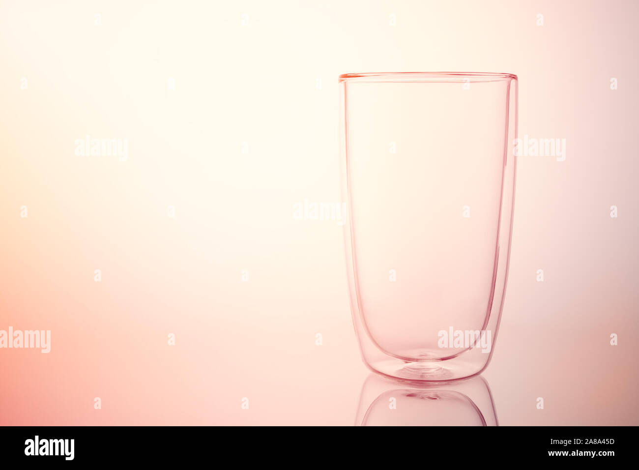 empty crystal glass on pink gold background, toned Stock Photo - Alamy