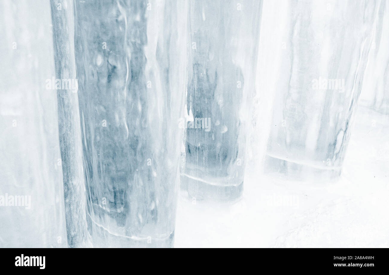 Thick pillars of cold blue ice crate an ice wall, receding into the ...