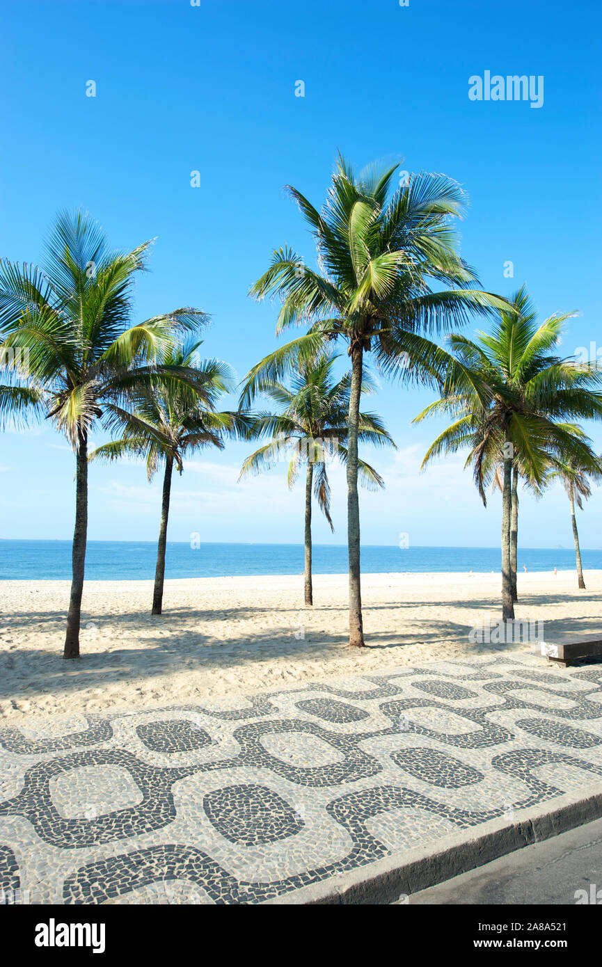 Bright sunny view of the iconic boardwalk at Ipanema Beach with palm ...