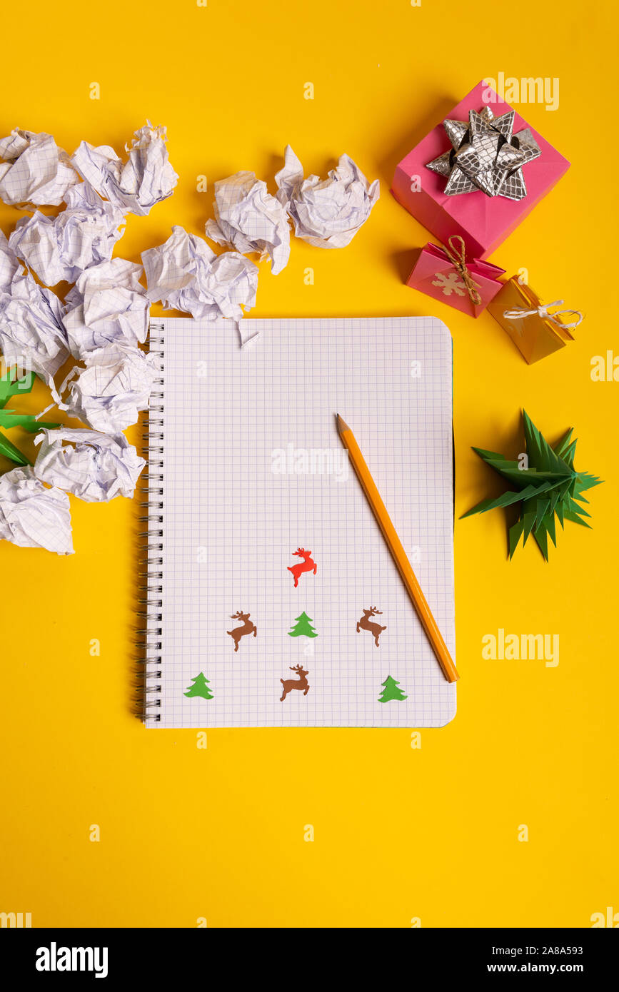 gift box and green origami trees with notepad on yellow desk, table ...