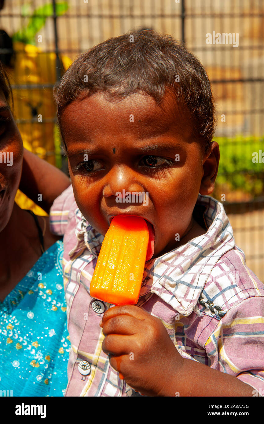 Small indian boy eating a popsicle at Chitradurga Fort, Karnataka ...
