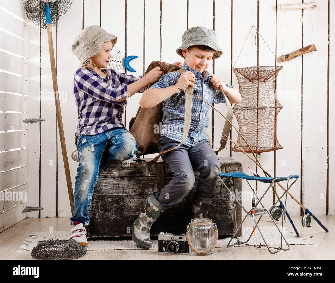 little girl and boy putting on backpack Stock Photo - Alamy