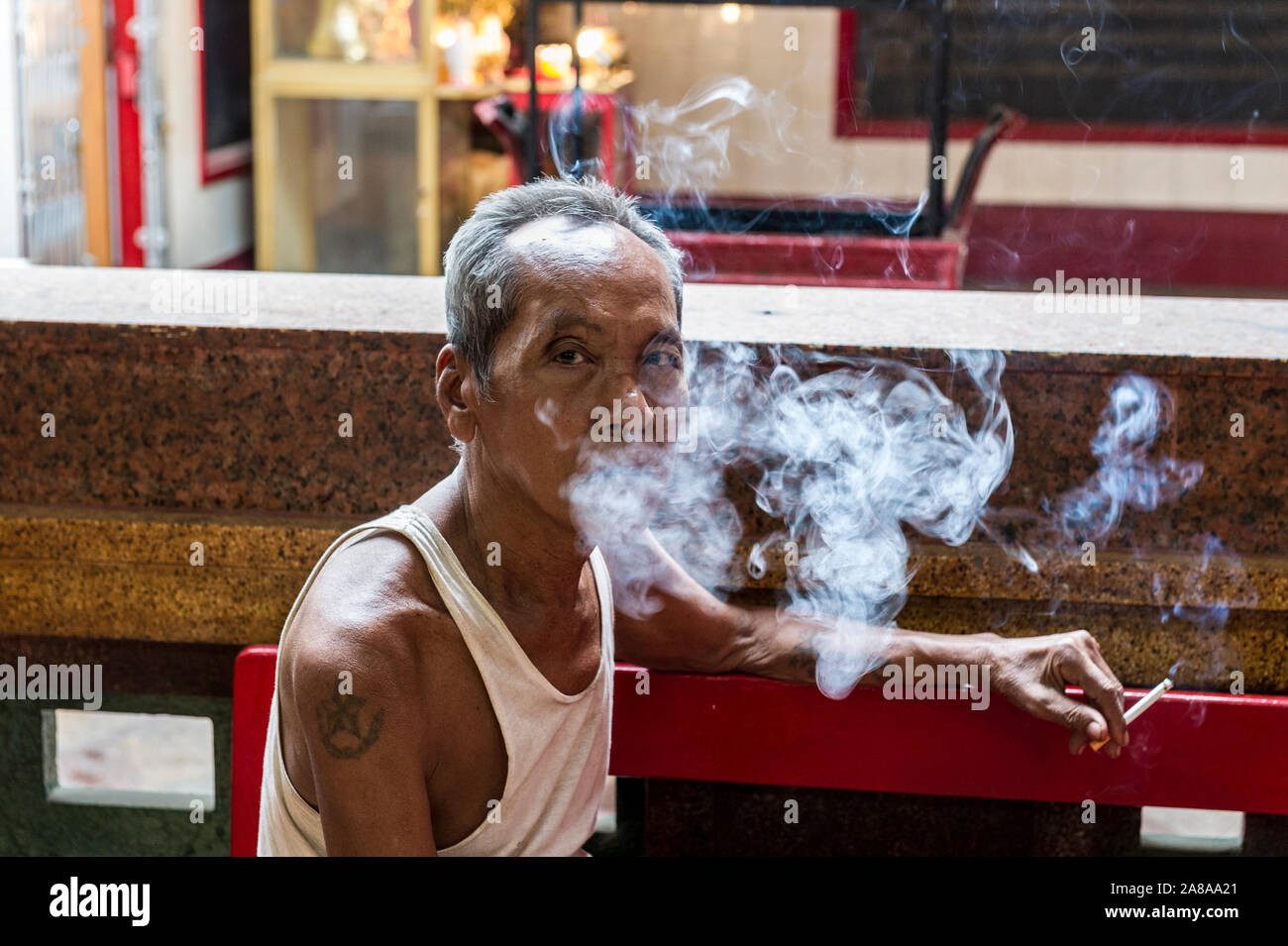 Man smoking a cigarette in the Chinatown area of Yangon, Myanmar Burma ...