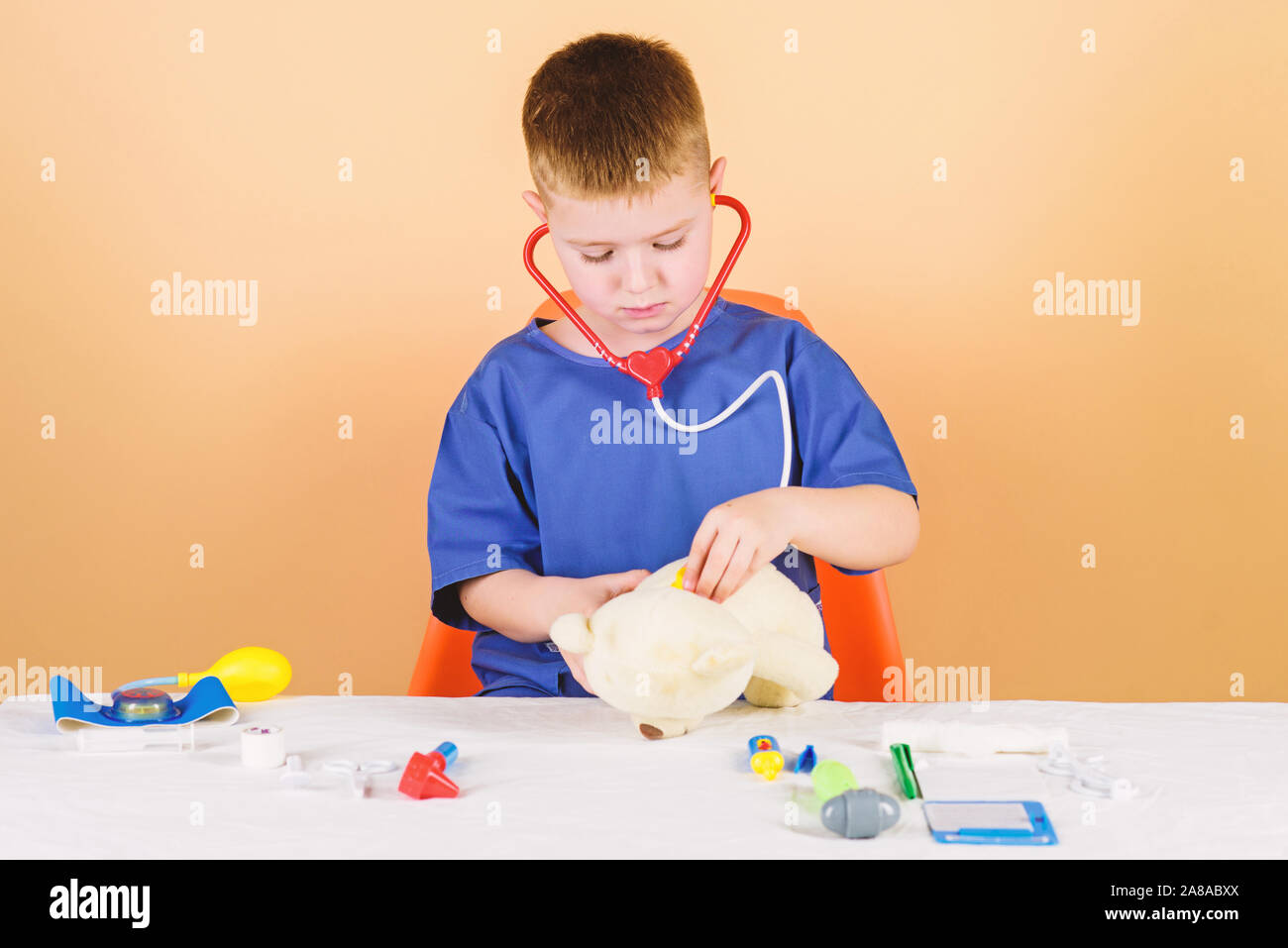 Health care. Kid little doctor busy sit table with medical tools ...