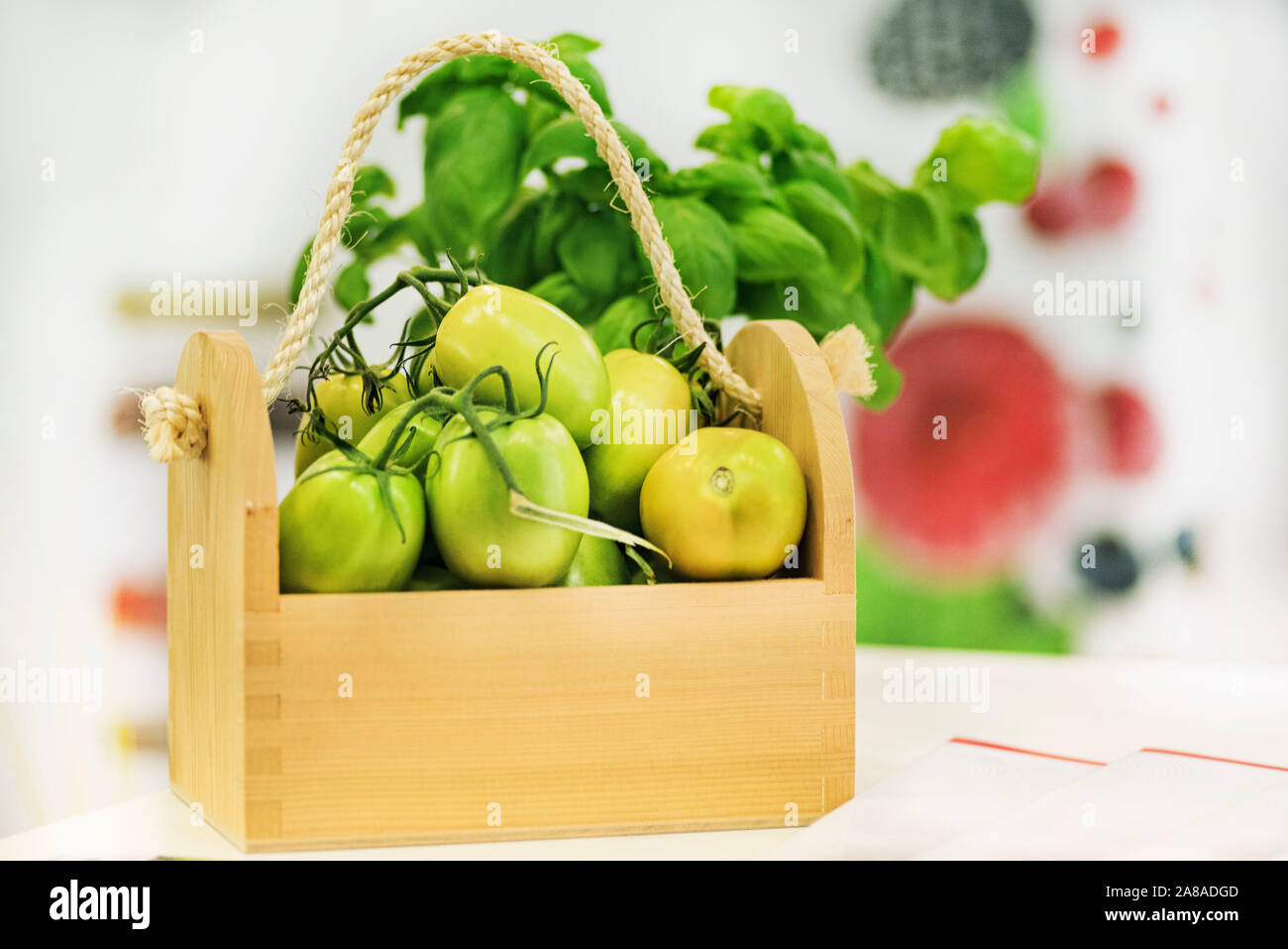 A close-up photo of a still-green tomato .Wooden crate with green ...