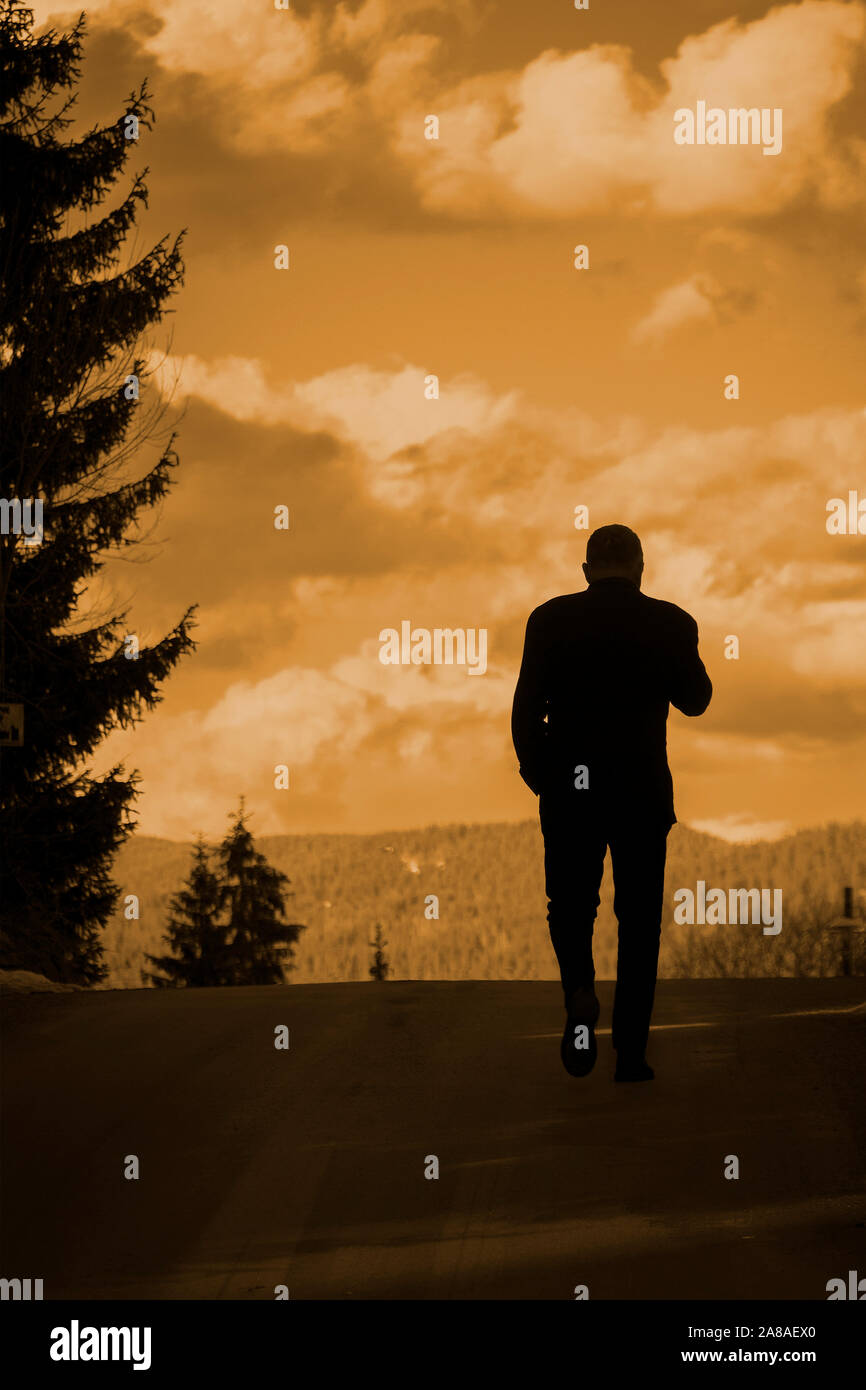 Silhouette of man walking uphill on a path trough the forest Stock ...