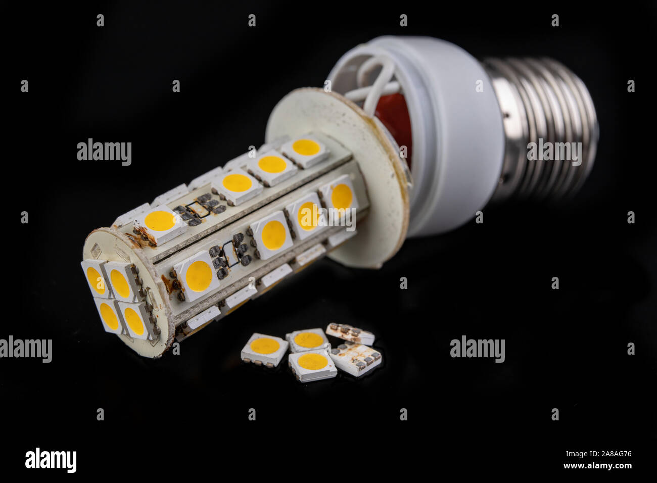 Broken led bulb on a dark table. Modern lighting under repair. Black ...