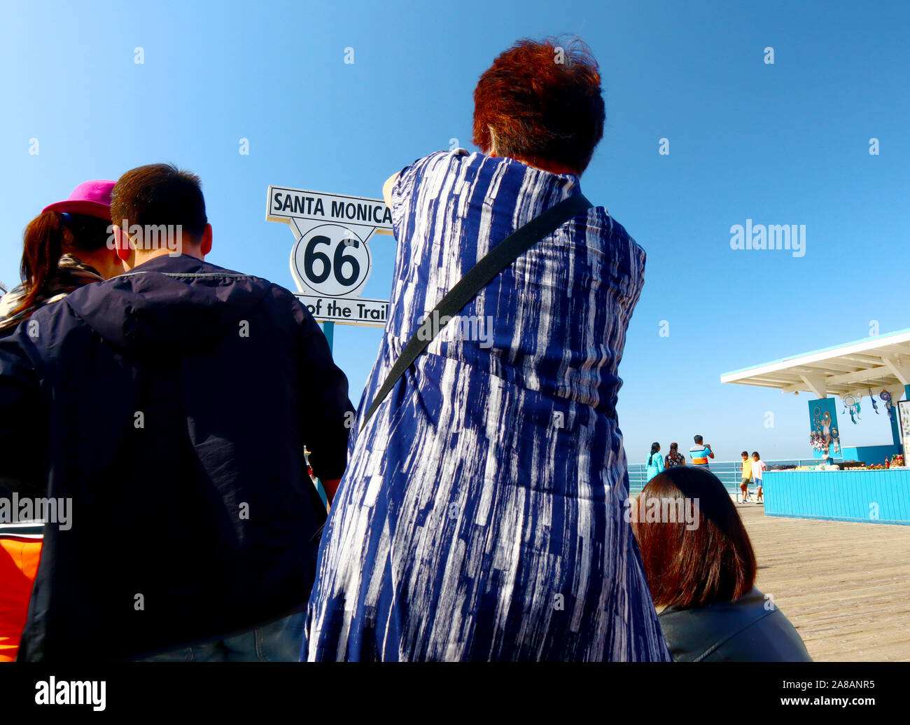 Tourists taking pictures of the sign Route 66 End of the Trail, located ...