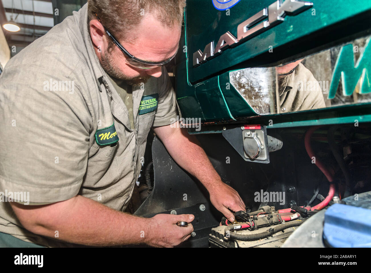 A technician performs routine maintenance on a Mack Pinnacle truck at ...