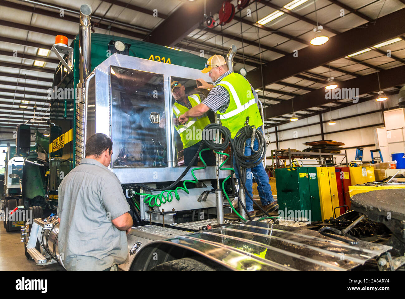 Technicians perform routine maintenance on a Mack Pinnacle truck at ...