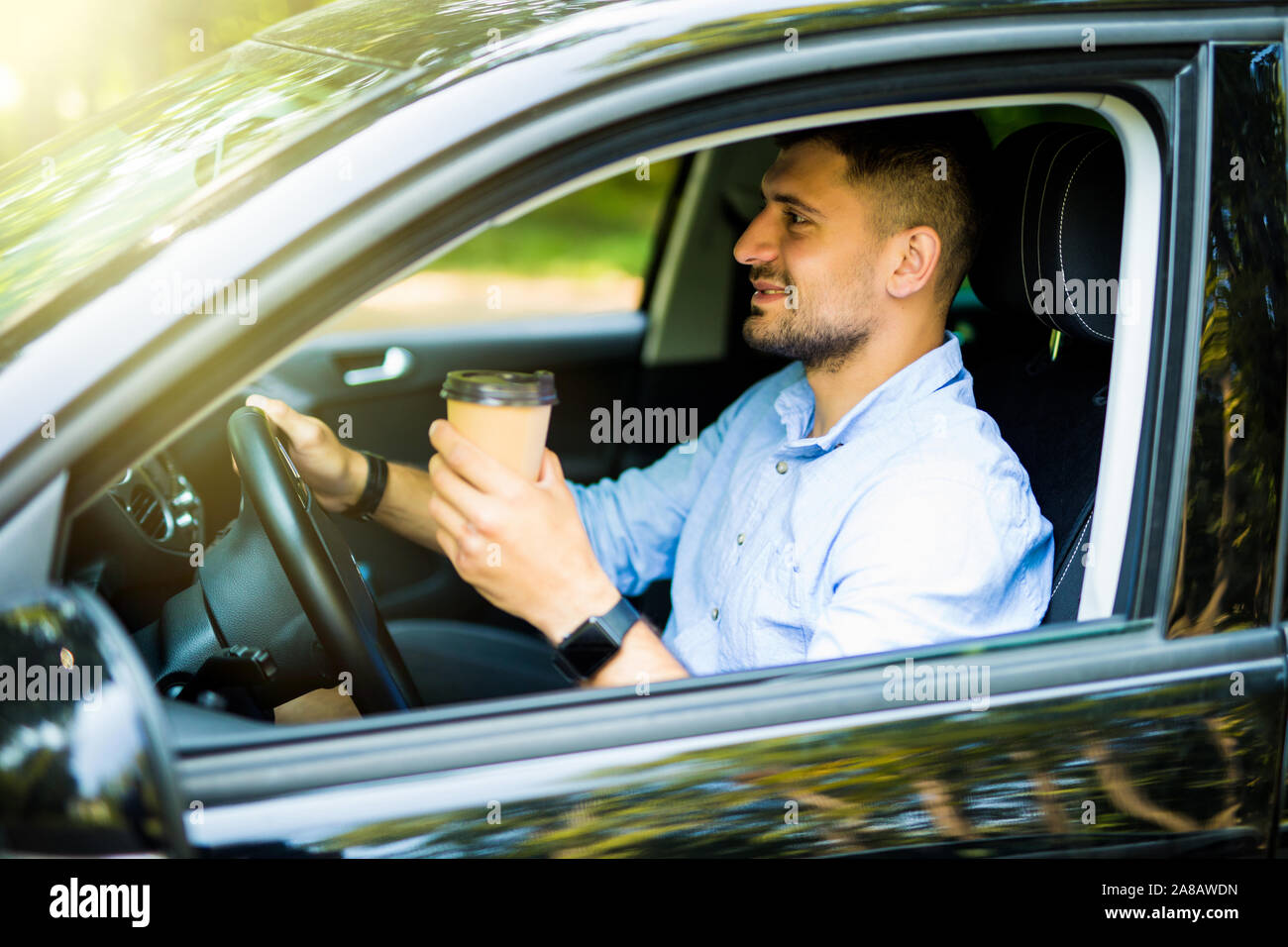 Man drinking coffee while driving the car Stock Photo - Alamy