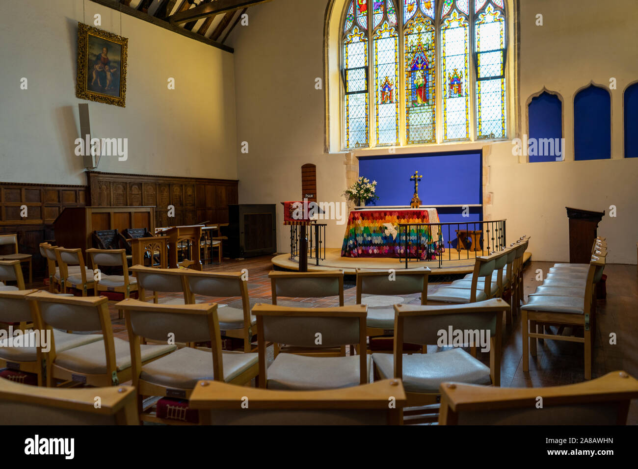 The altar of an anglican church with a stained glass window behind ...