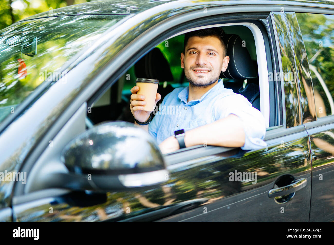transportation and vehicle concept - man drinking coffee while driving ...