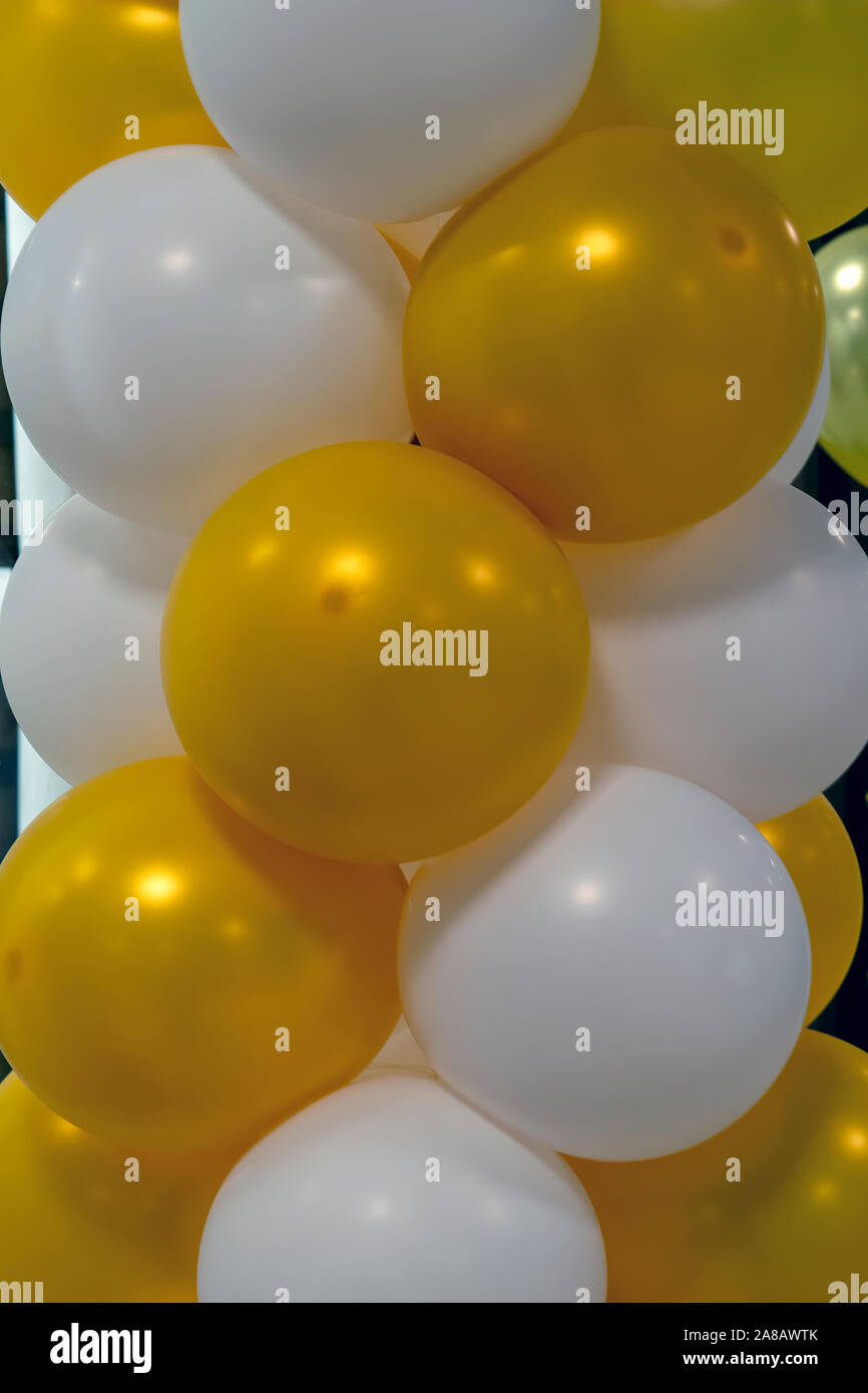 Yellow and white balloons close-up. A bunch of yellow and white ...