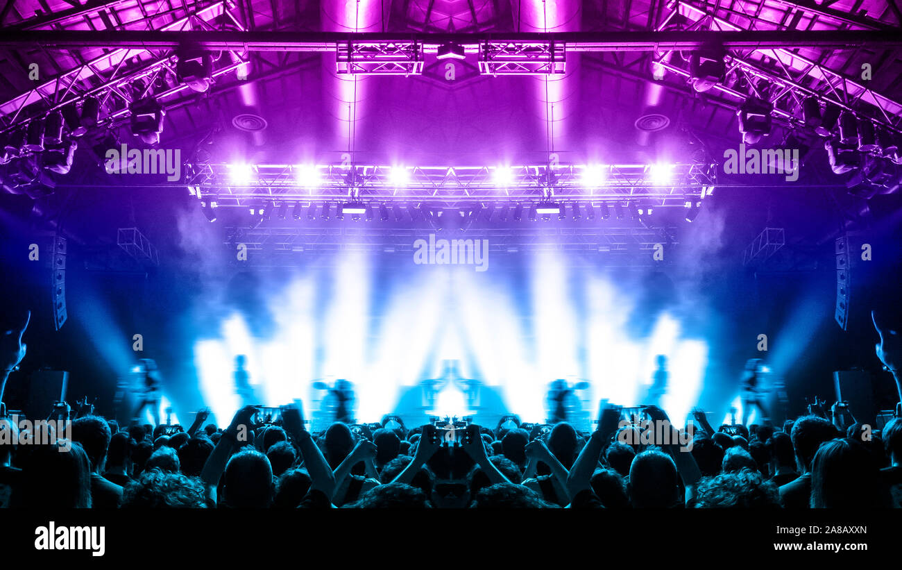 Shot taken inside a concert hall, in the middle of the crowd. The main ...